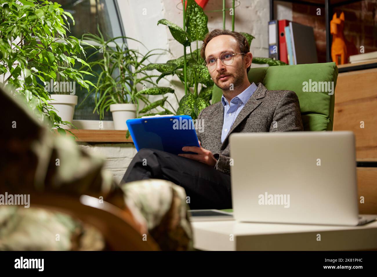 Two people, soldier in military uniform and psychologist at therapy ...