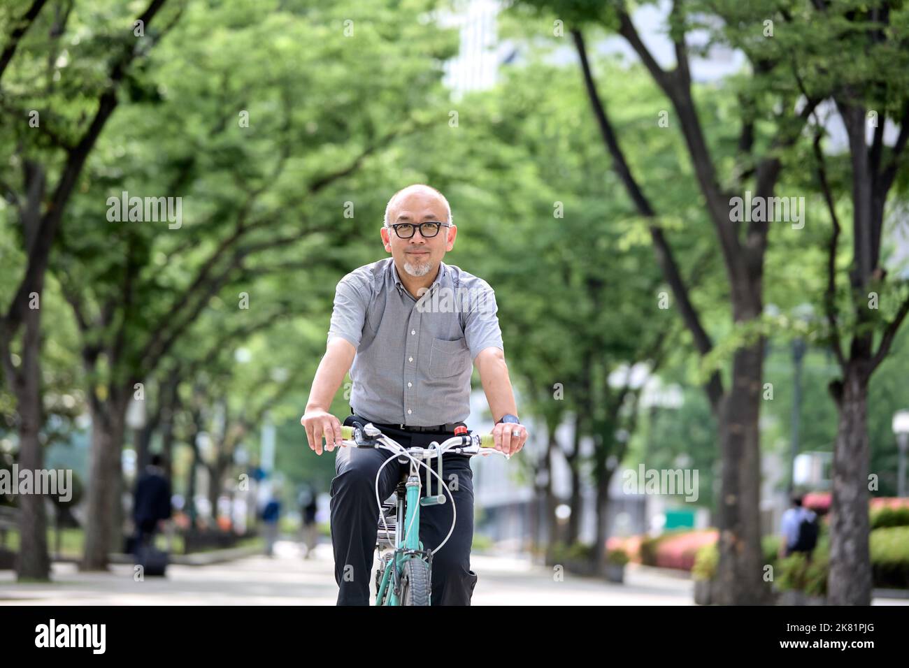 Japanese man riding a bike Stock Photo - Alamy