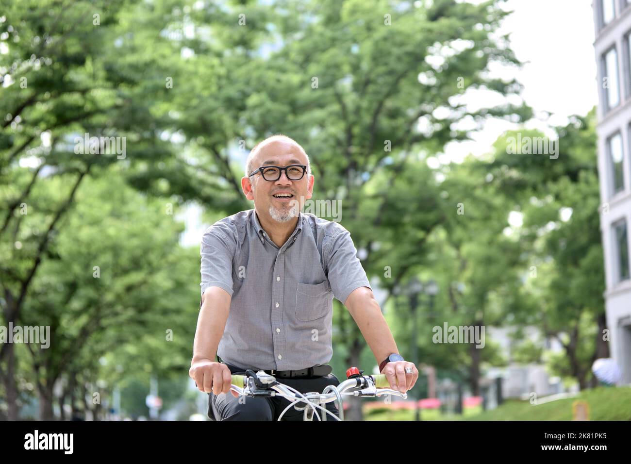 Japanese man riding a bike Stock Photo - Alamy