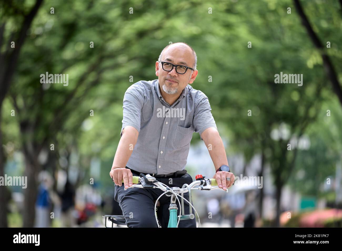 Japanese man riding a bike Stock Photo - Alamy
