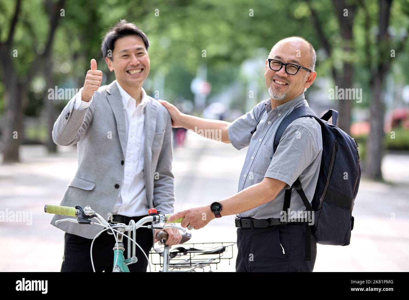 Smiling Japanese men with bike Stock Photo - Alamy