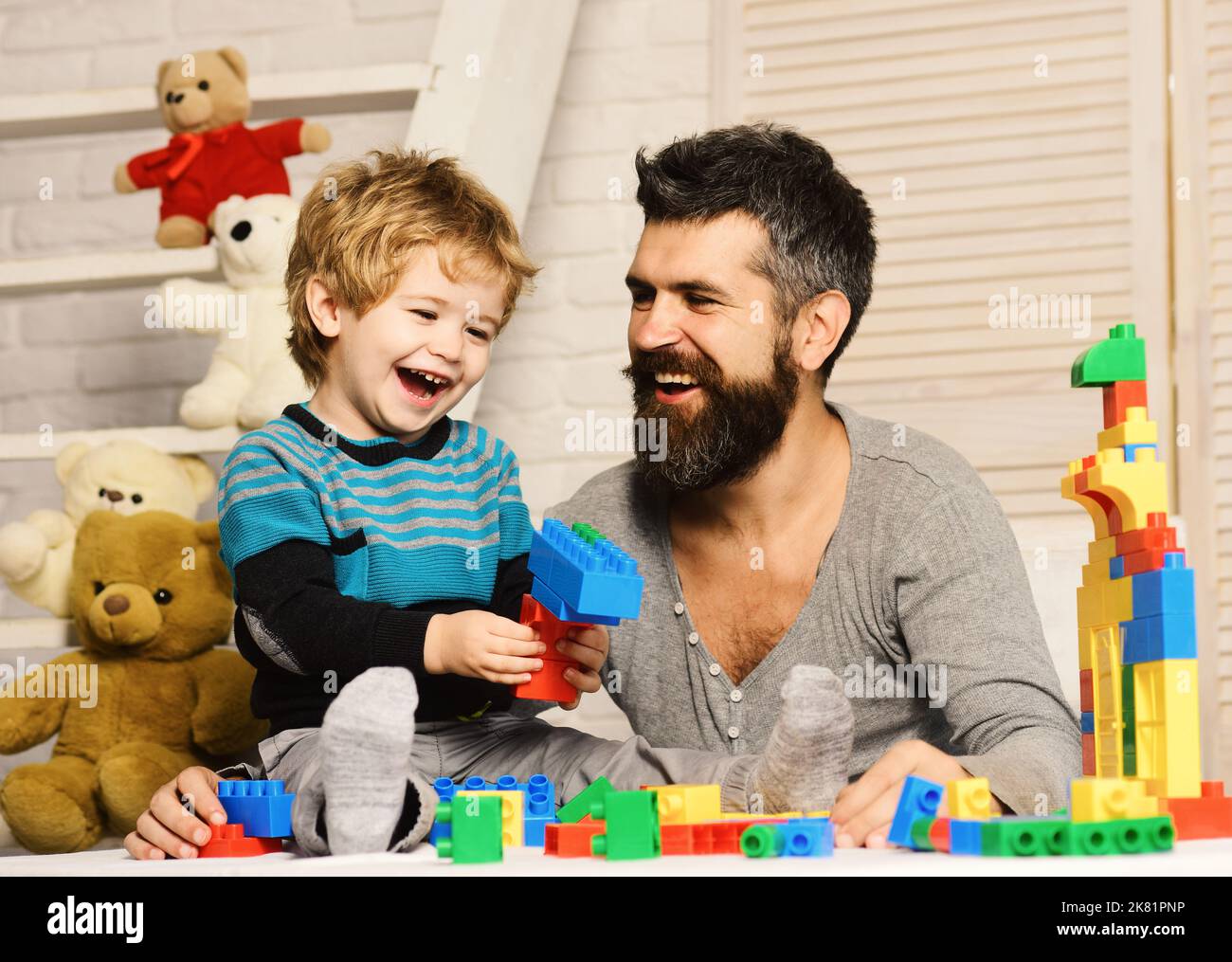 Boy and man play together. Dad and kid with toys Stock Photo - Alamy