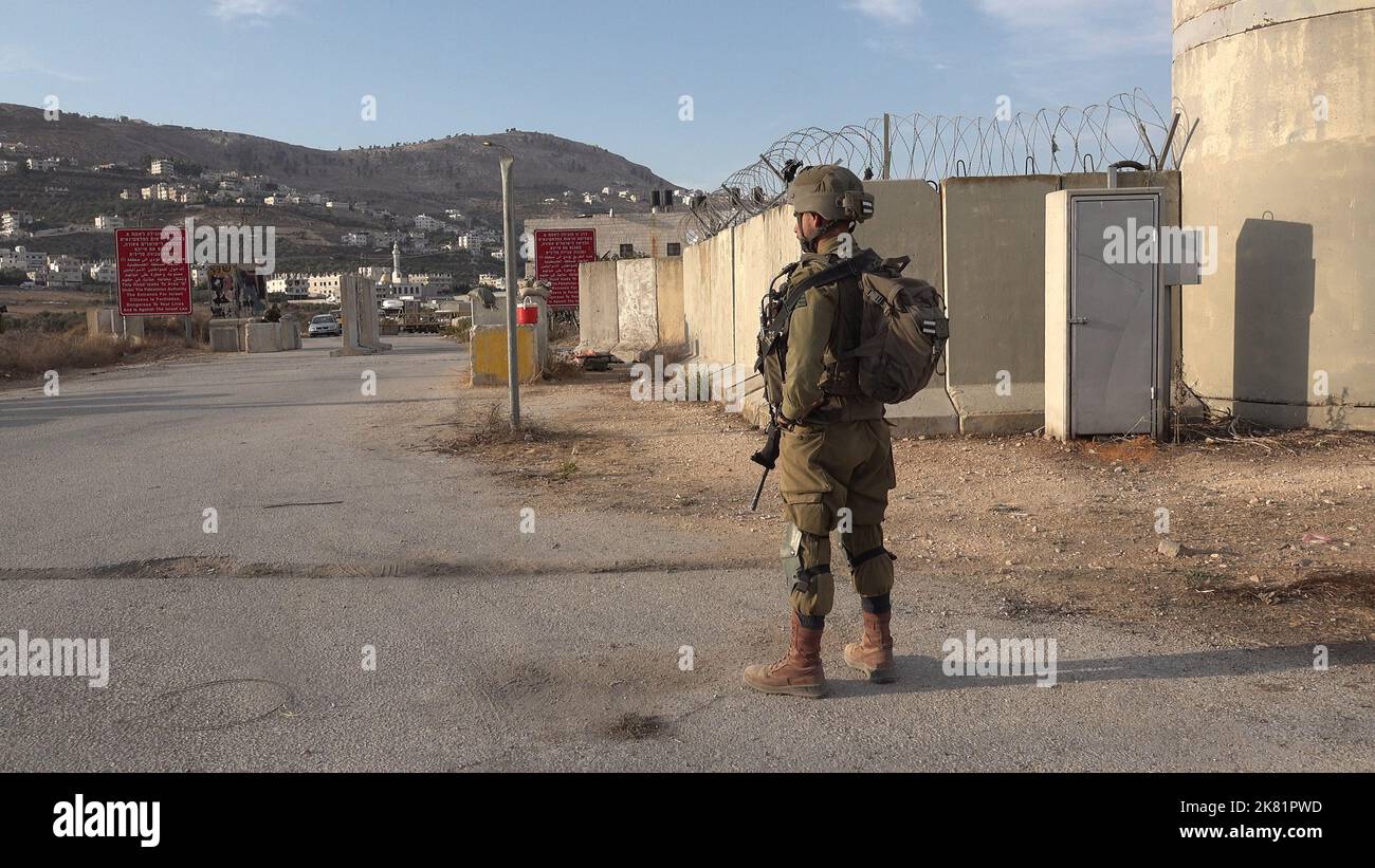 An armed Israeli soldier stands guard in the military Awarta checkpoint ...