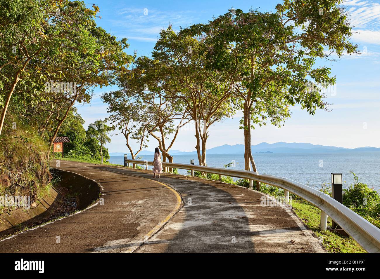 A woman walking on the concrete road at coastline Stock Photo - Alamy
