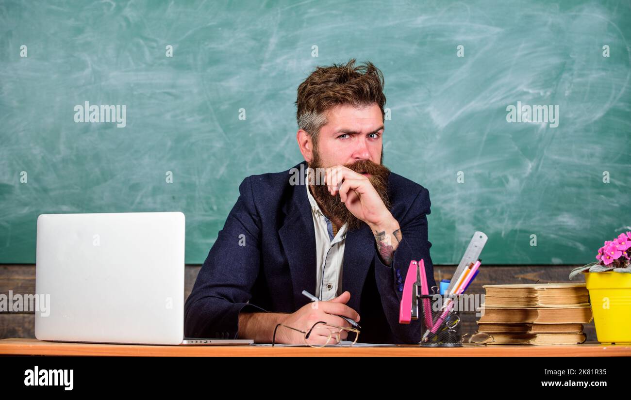 Not sure in knowledge. Examiner full of doubts sit at table chalkboard ...