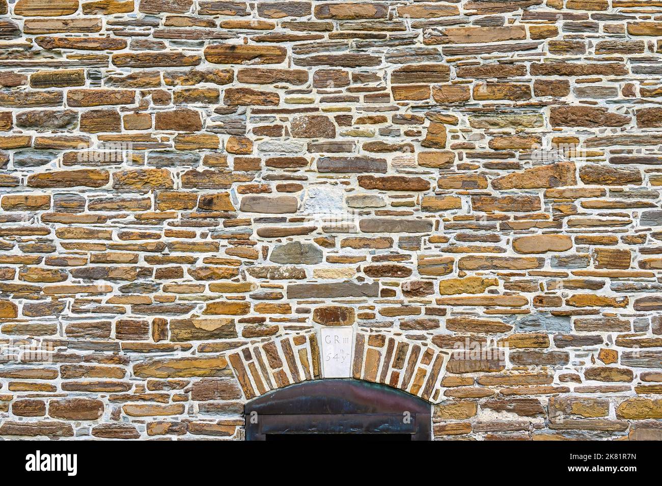 Stone wall and arch on top of an entrance door of a fortified building ...
