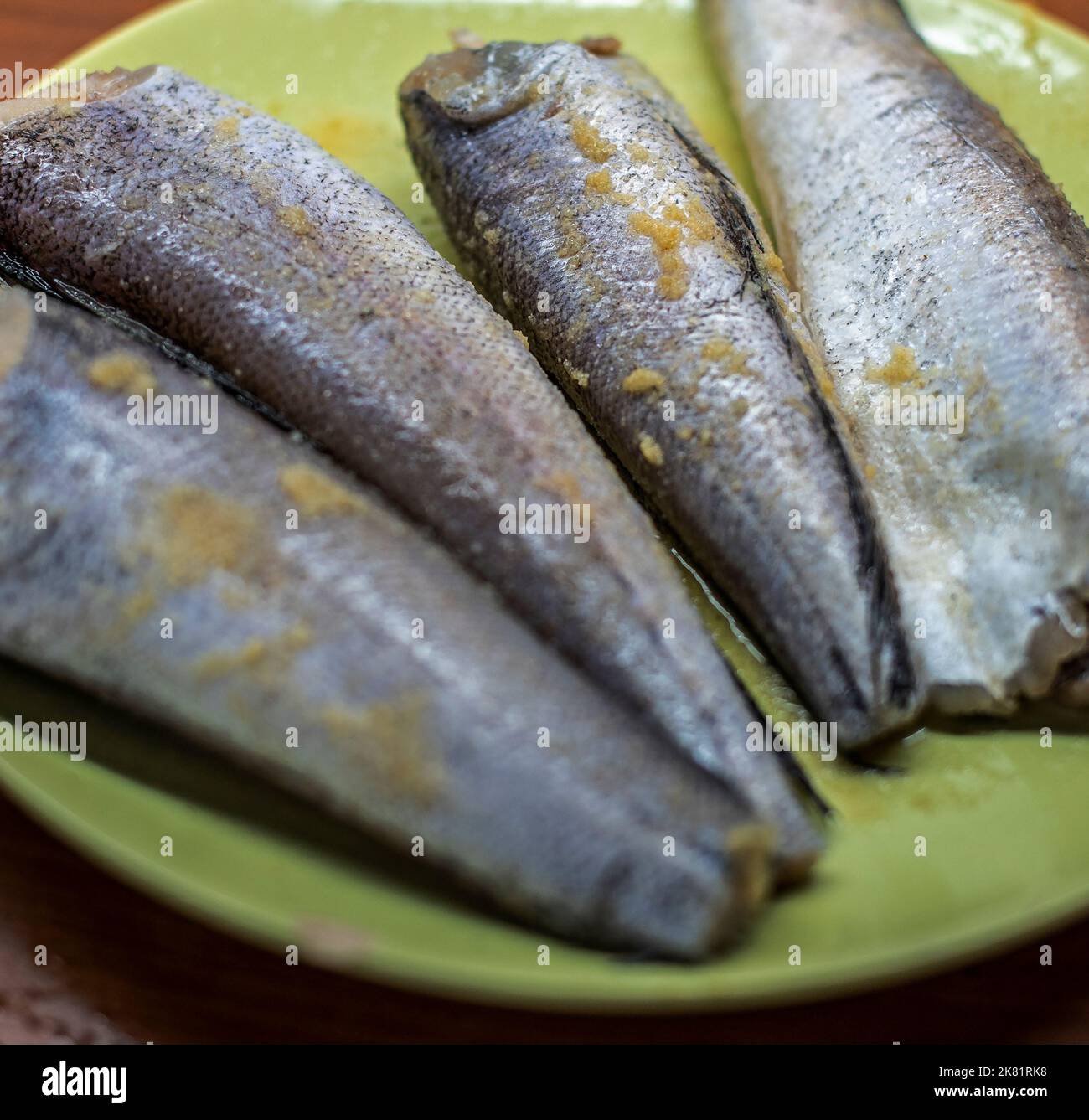 Many headless raw hake fish on plate Stock Photo - Alamy