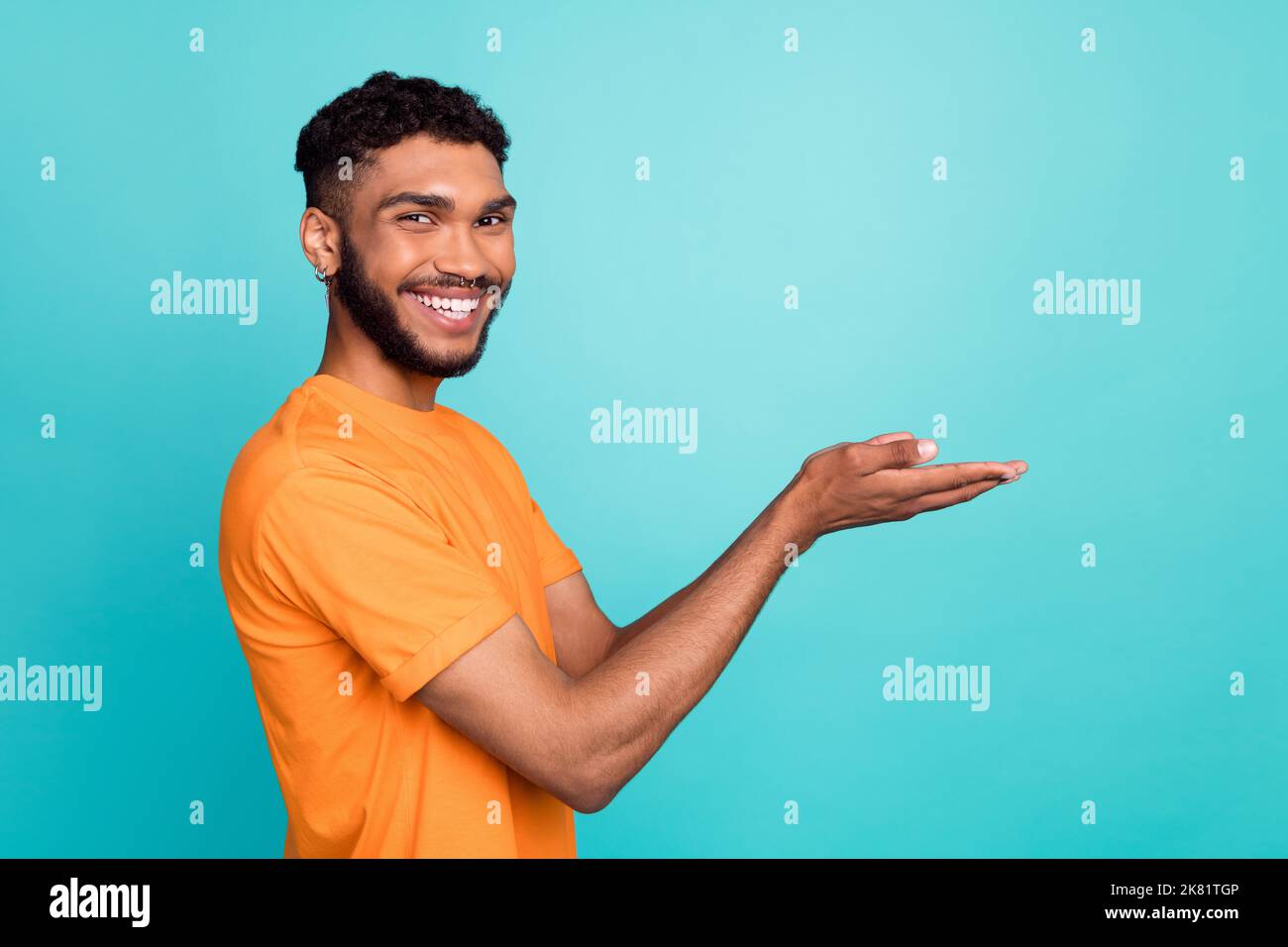 Photo Of Funny Attractive Guy Wear Orange T Shirt Holding Arms Empty