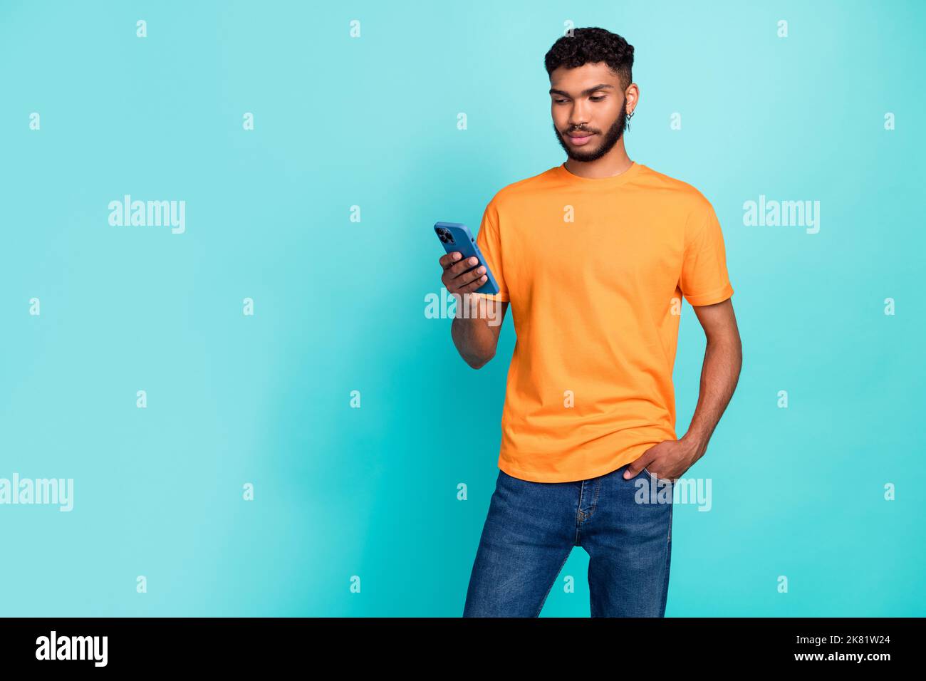 Photo of serious confident man dressed orange t-shirt writing sms ...