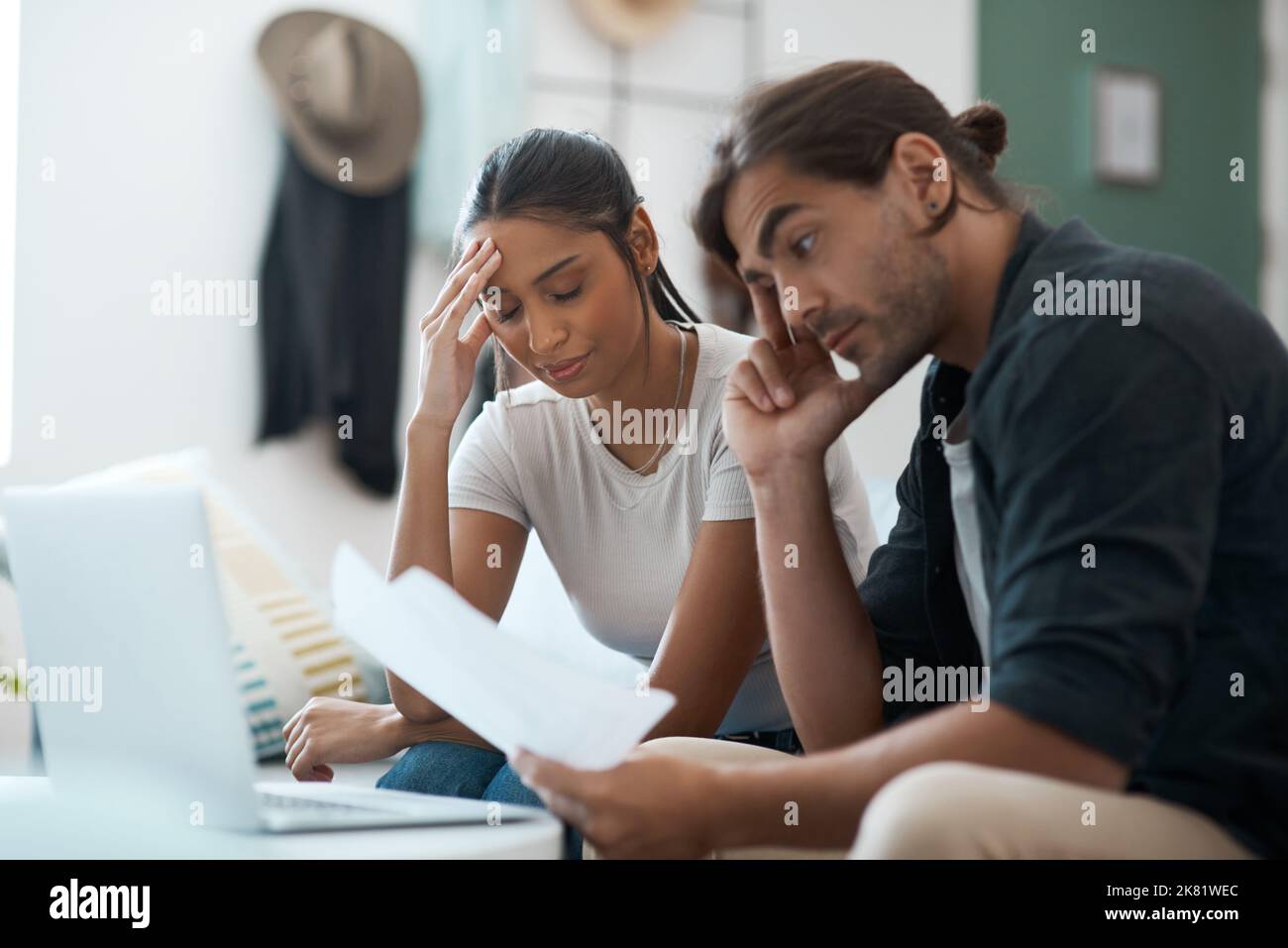 This paperwork is stressful. a young couple doing paperwork while using ...