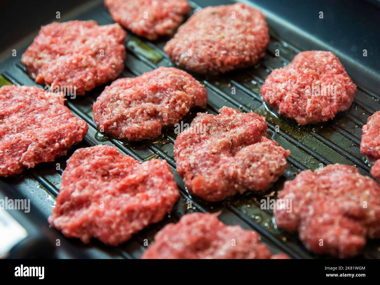 Frying four round beef meat for hamburger Stock Photo - Alamy