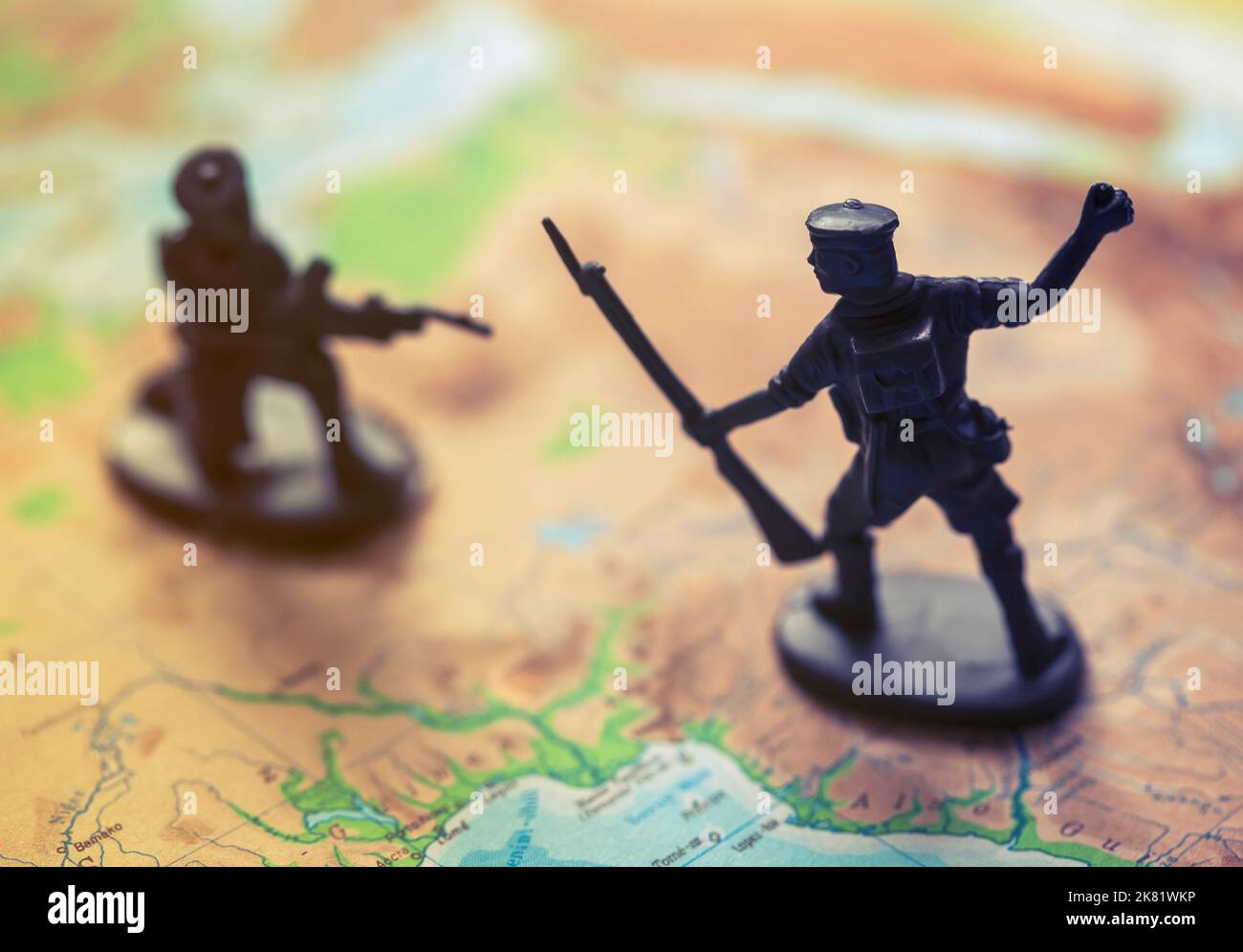 Miniature armed soldier toy with gun on map, symbol of war conflict ...