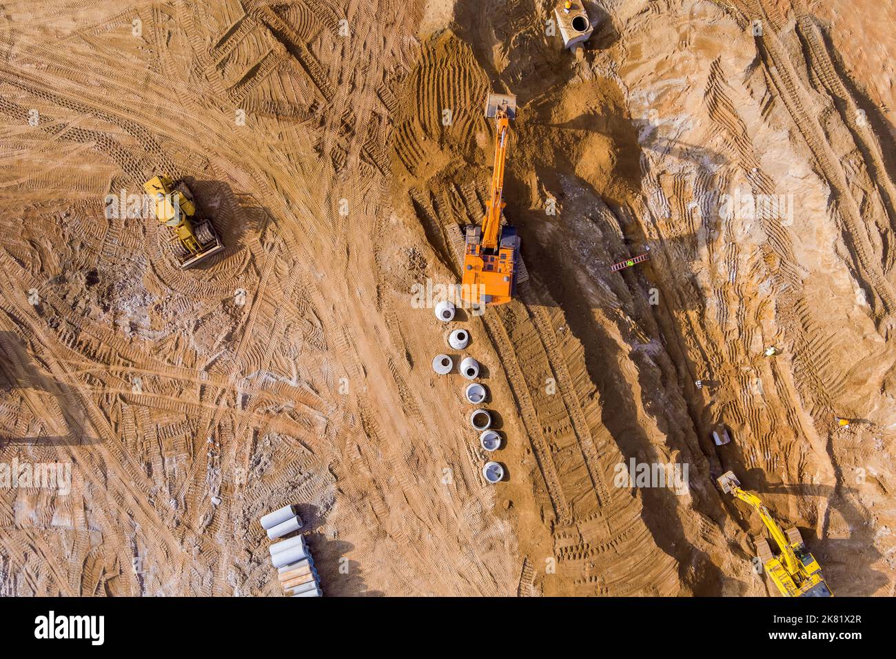 At construction site, an excavator digs trench in order to lay sewer ...