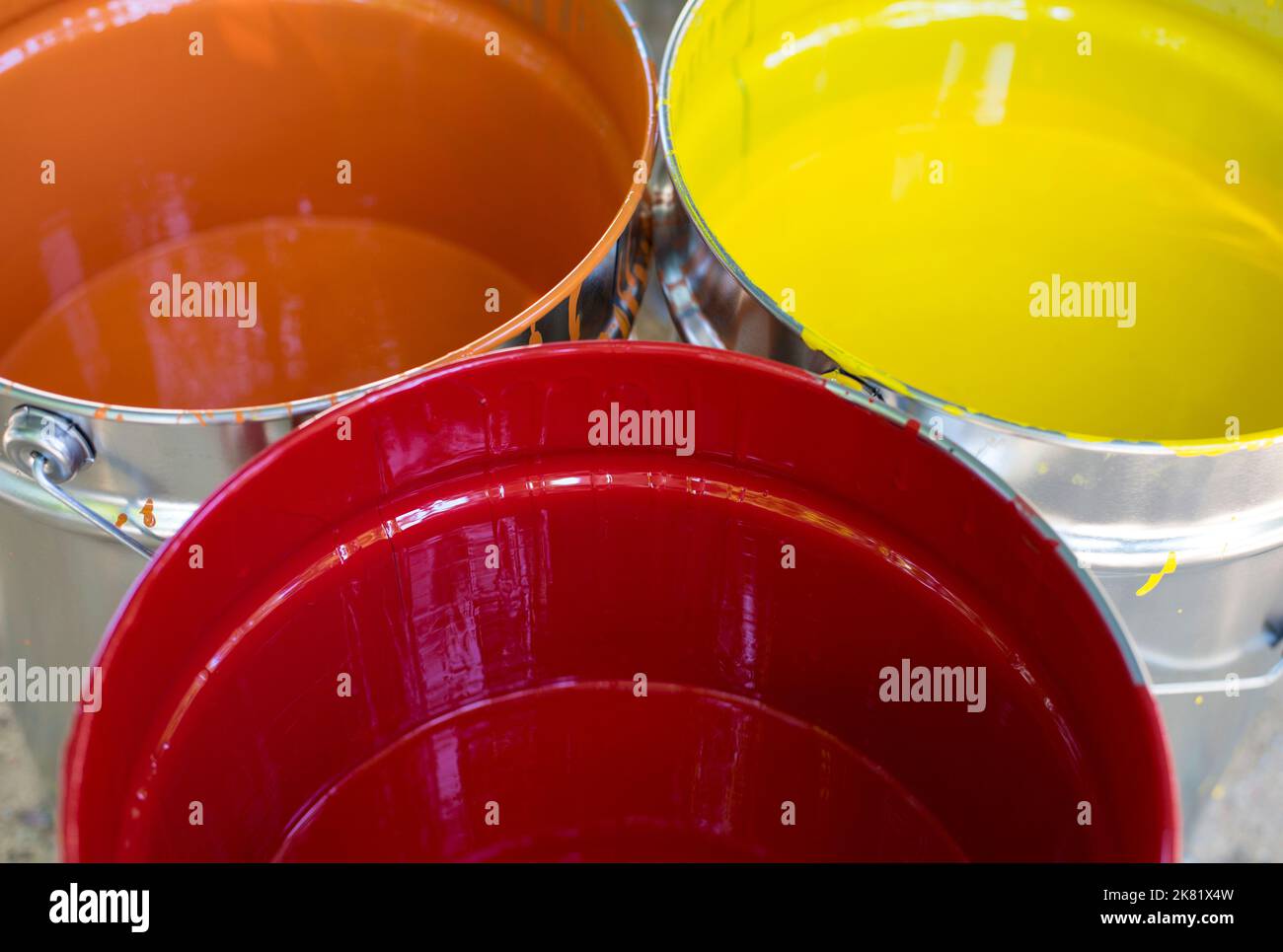 Red, yellow and orange paint in paint bucket Stock Photo - Alamy