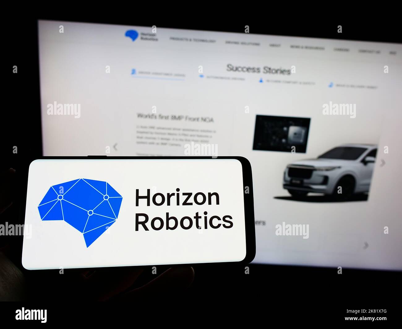 Person holding mobile phone with logo of Chinese automotive company ...