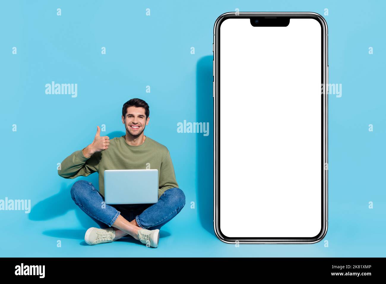 Full length photo of positive guy sit floor use netbook show thumb up ...