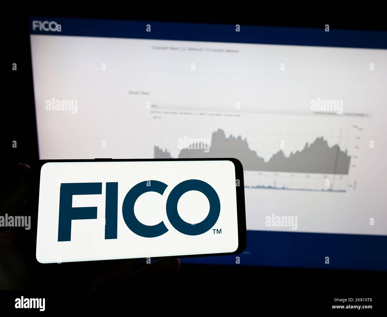 Person holding mobile phone with logo of American company Fair Isaac Corporation (FICO) on ...