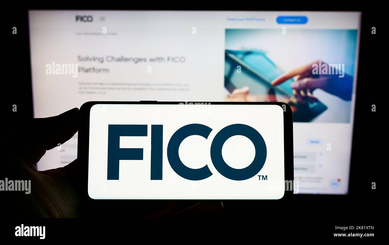 Person holding cellphone with logo of US company Fair Isaac Corporation ...