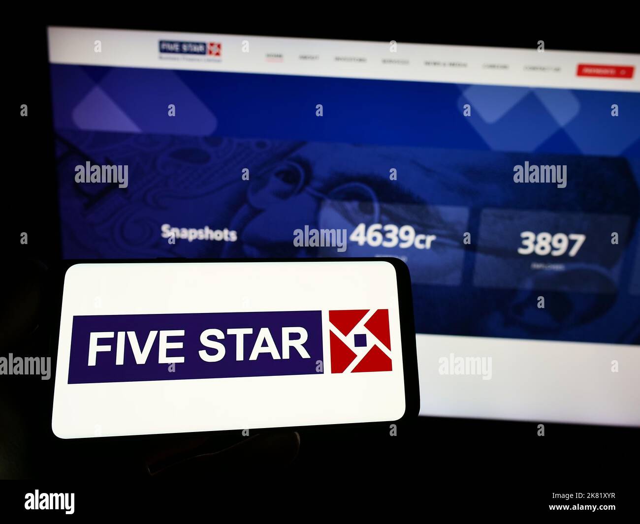 Person holding smartphone with logo of Indian company Five-Star ...