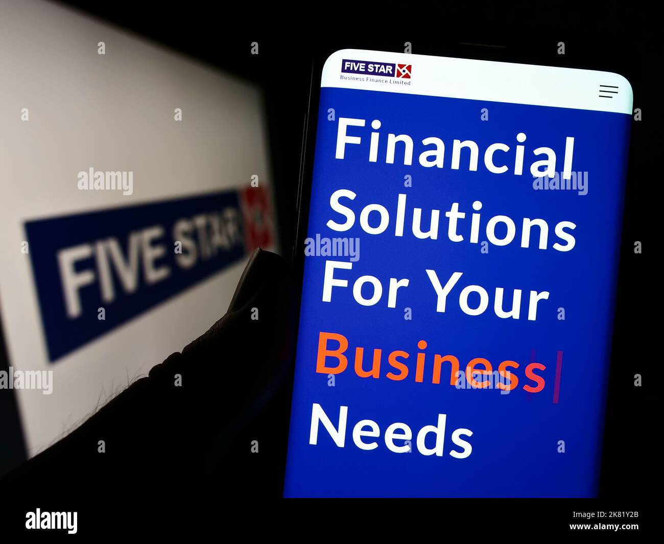 Person holding cellphone with website of company Five-Star Business ...