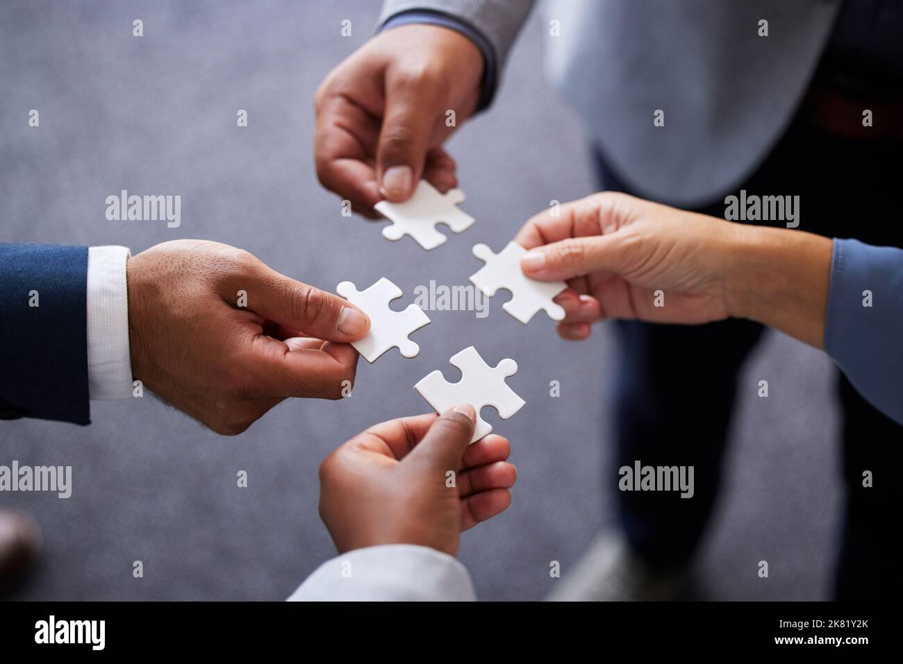 We get things done through collaboration. four businesspeople holding ...