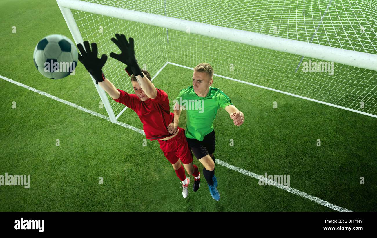 Soccer goalkeeper in action on soccer stadium. Goalkeeper hits the ball ...