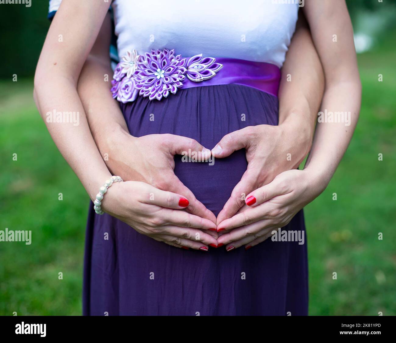 Pregnant woman she and her husband touch belly Stock Photo - Alamy
