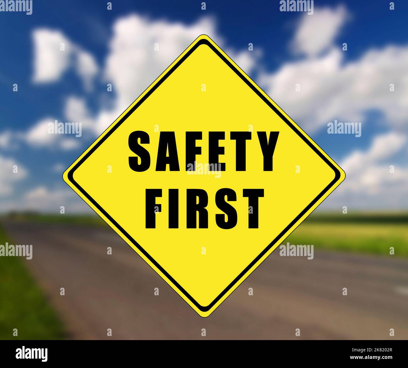 Road with yellow traffic sign safety first text on it Stock Photo - Alamy