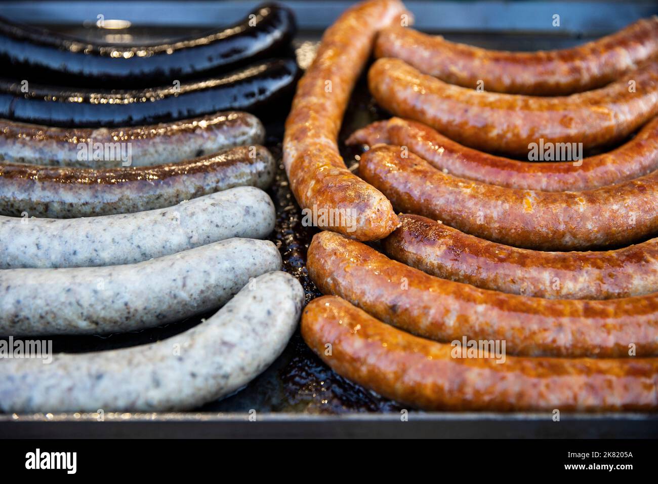 Traditional german street food - fried sausages in big frying pan Stock ...