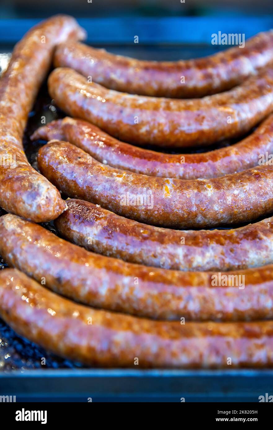 Traditional german street food - fried sausages in big frying pan Stock ...