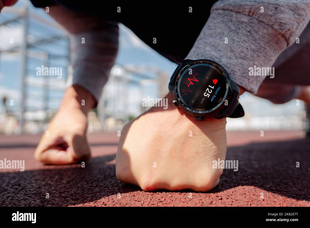 a man sports a smartwatch. the guy does push-ups at the stadium. An ...