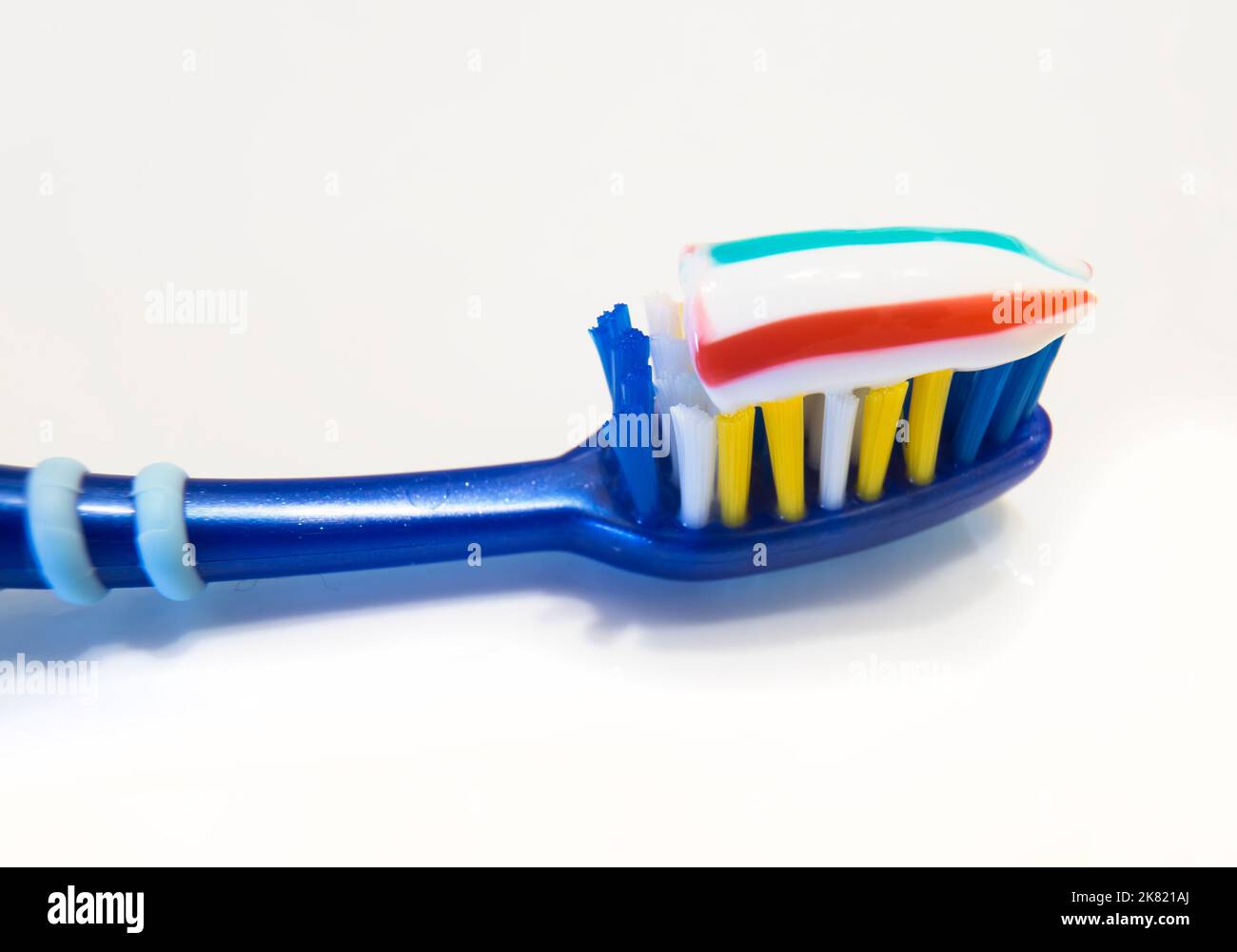 Stripped toothpaste on toothbrush isoltaed on white Stock Photo - Alamy
