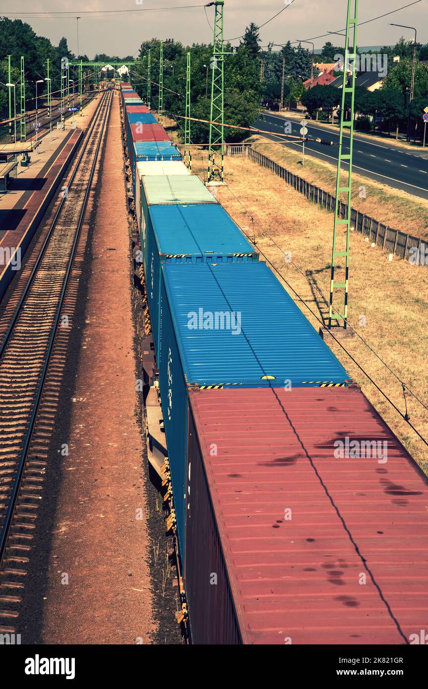 Long freight train with containers at railway station Stock Photo - Alamy