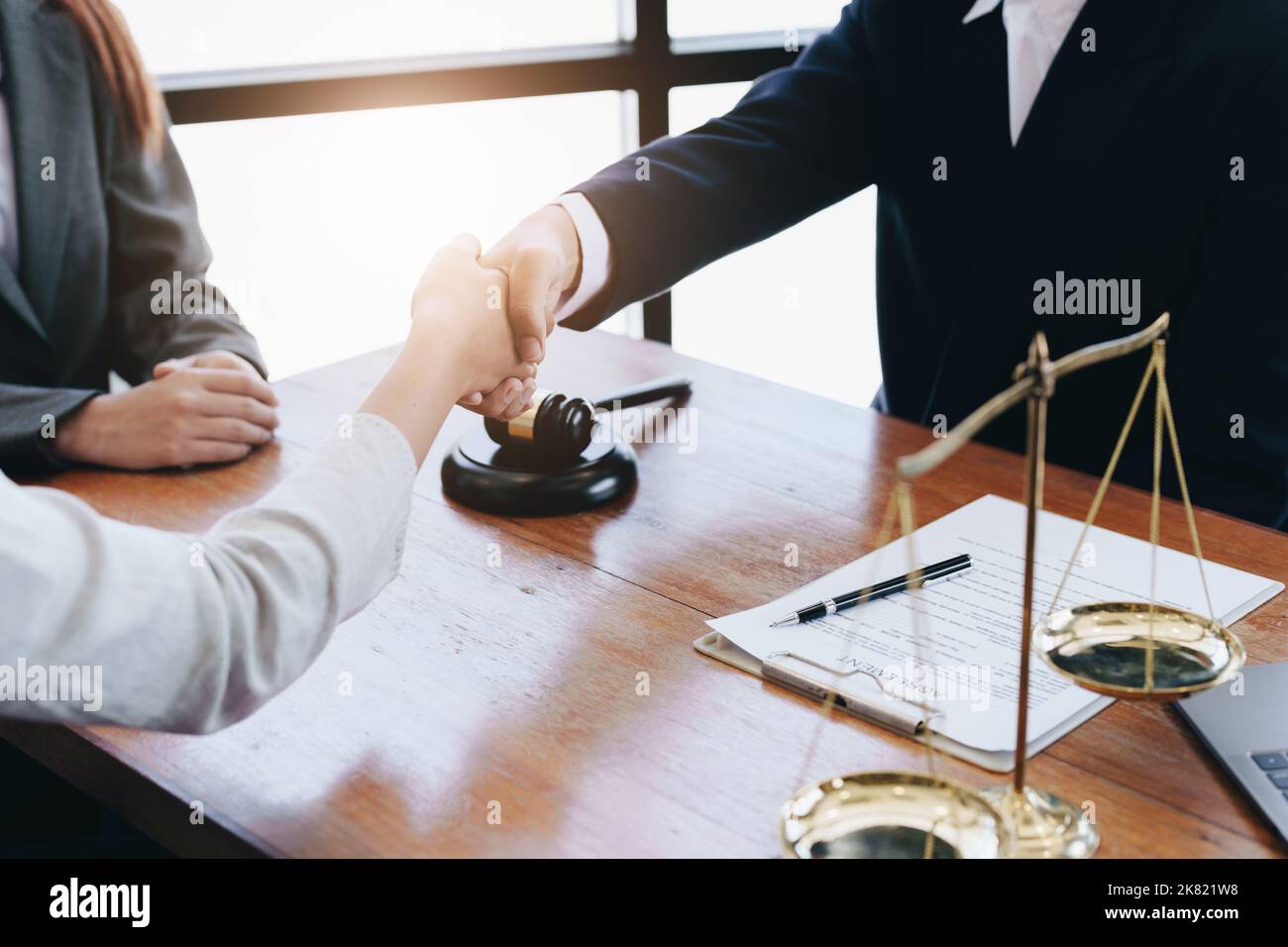 Lawyers shake hands to make Keating for clients Stock Photo - Alamy