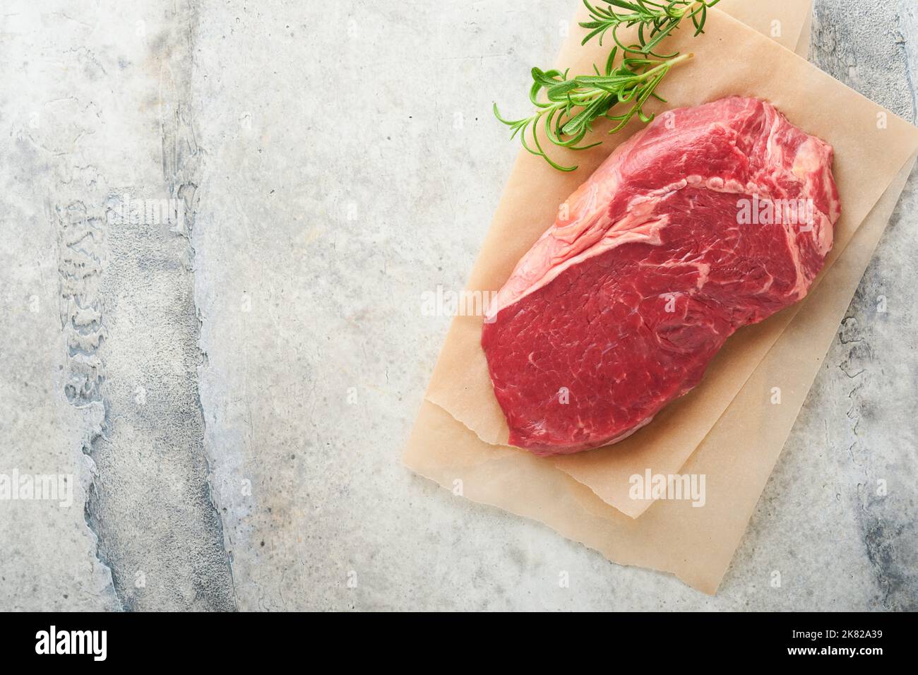 Raw beef steak. Fresh beef rib eye steak with fork rosemary, salt and ...