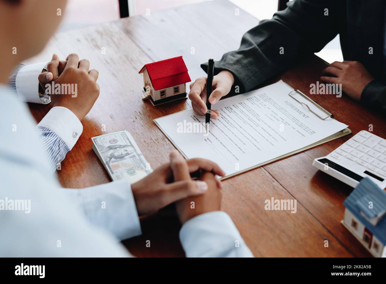 A couple is reading a home purchase contract before signing documents ...