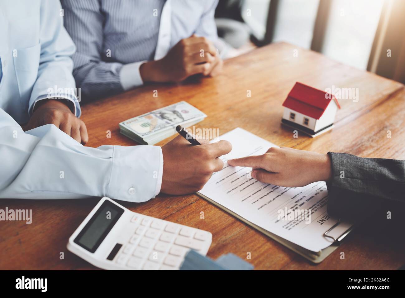 A couple is reading a home purchase contract before signing documents ...