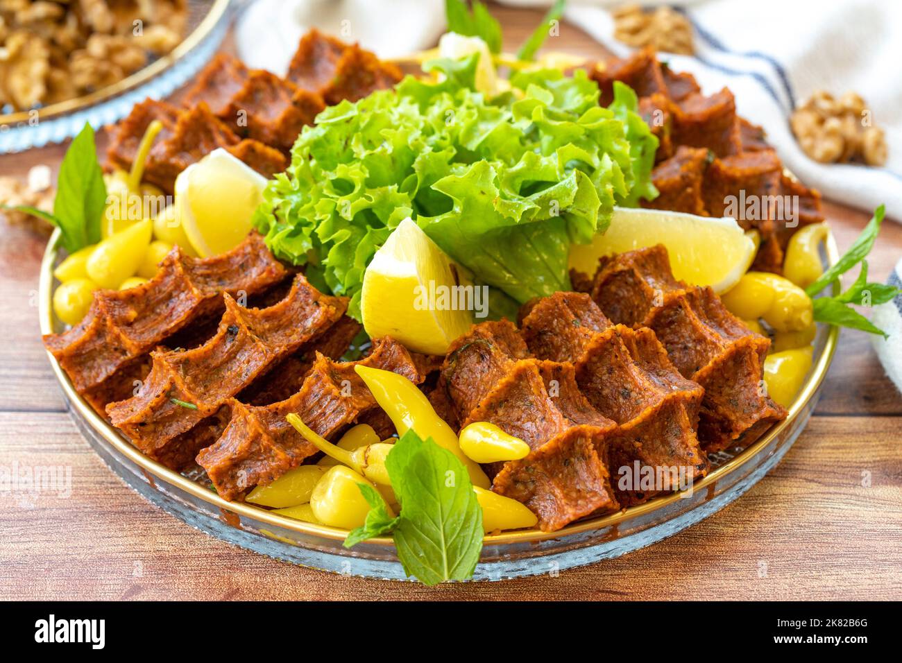 Cig kofte or raw meatballs on wood background. Traditional Turkish cuisine delicacies. Close-up ...
