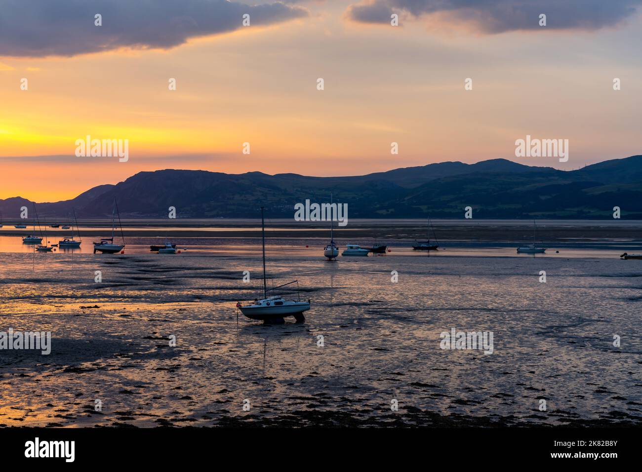 Colorful sunrise on the Menai Strait and mountains of Snowdonia at low ...