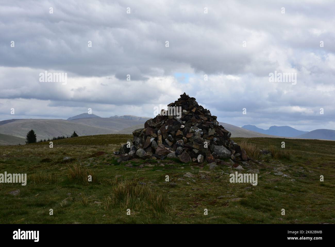 Stone cairn waymarker at the peak of a large hill Stock Photo - Alamy