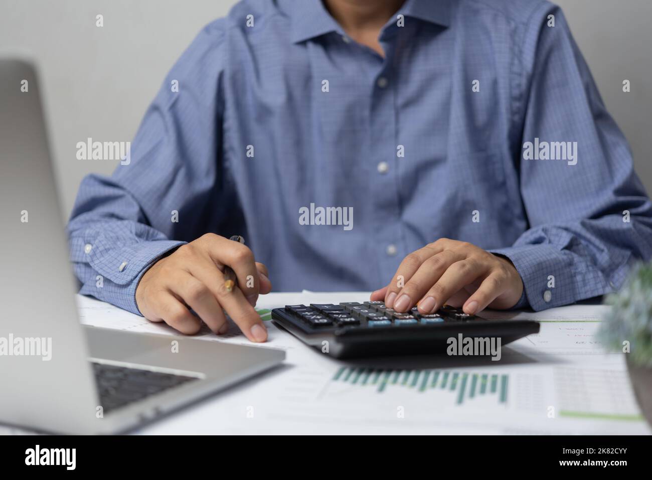 Business man hand using calculator holding pen and with doing finance ...