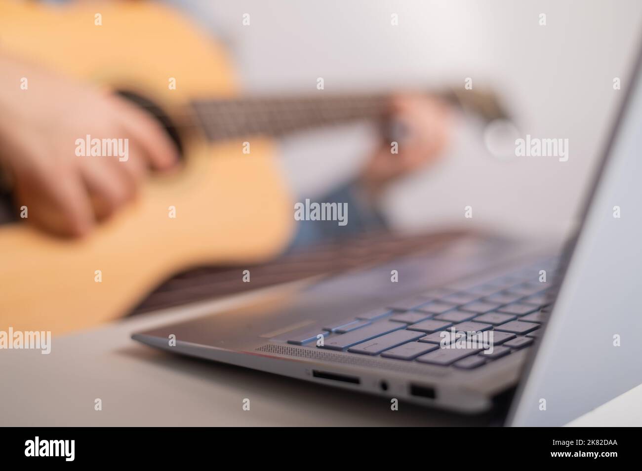 Faceless woman playing guitar and streaming live on laptop Stock Photo ...