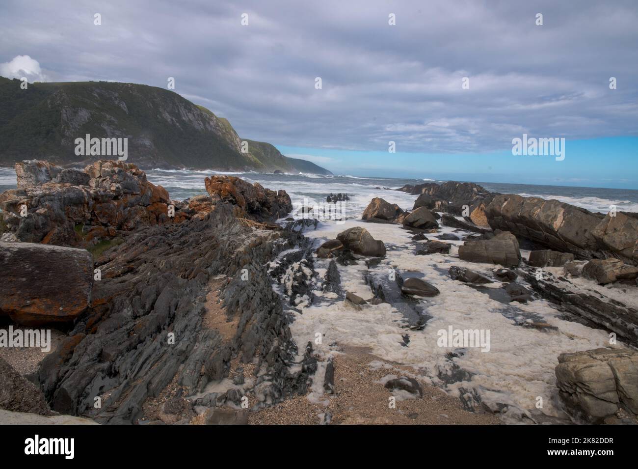 Crashing waves against jutting rocks on shoreline Stock Photo - Alamy