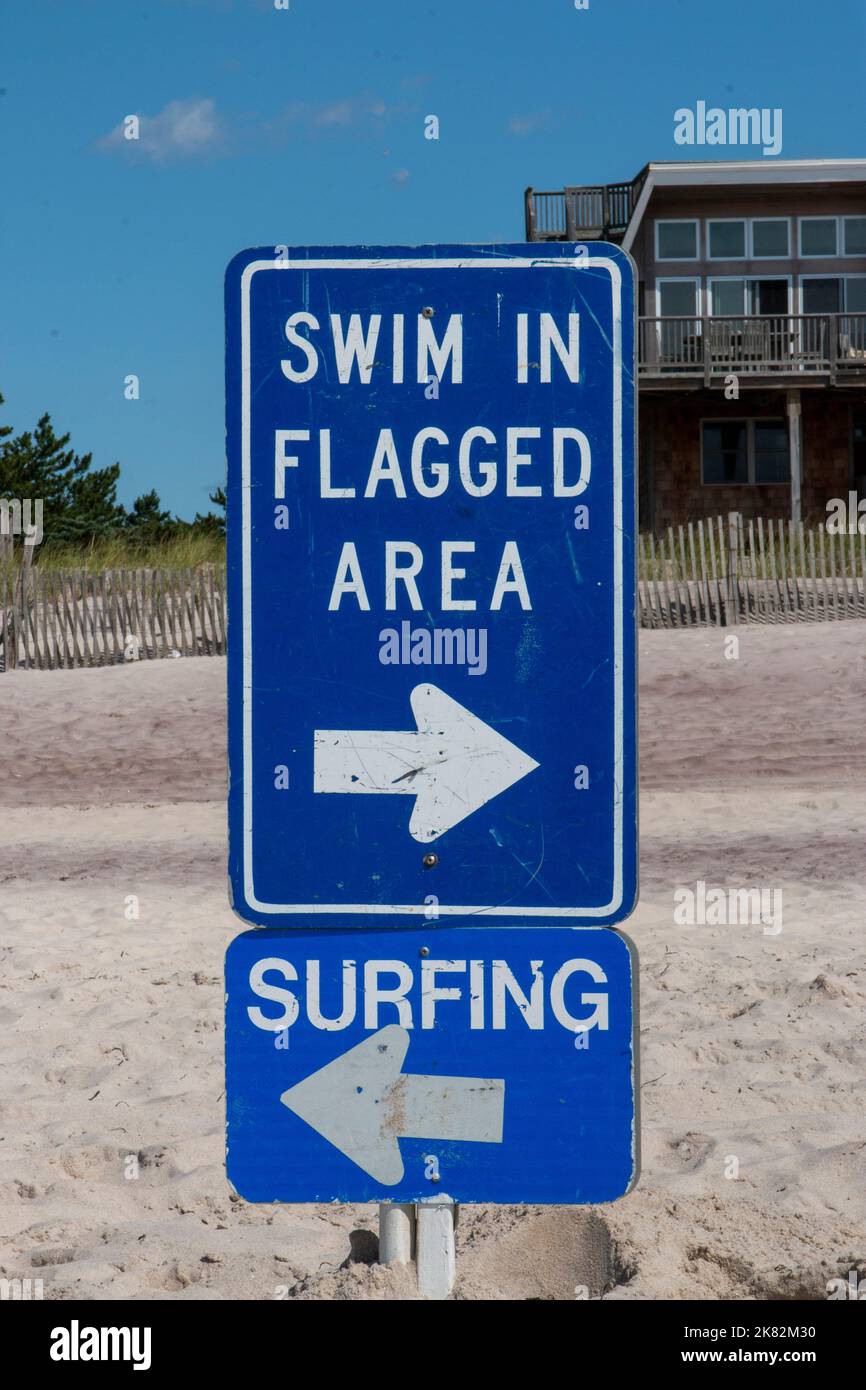 Sign on a beach pointing where to surf and where to swim on Fire Island ...