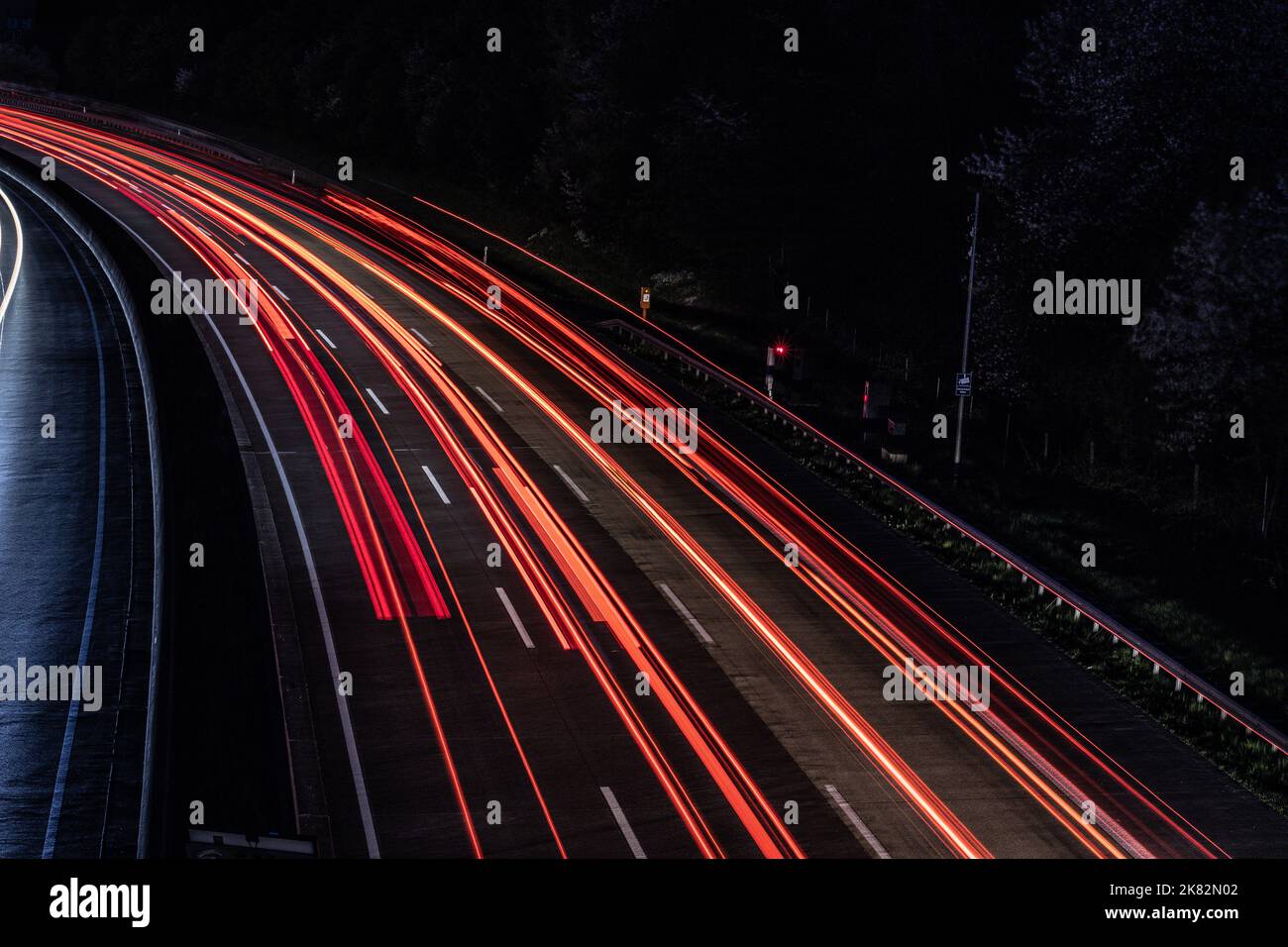 Autobahn nachts mit Landstraße und fahrenden Fahrzeugen Stock Photo - Alamy