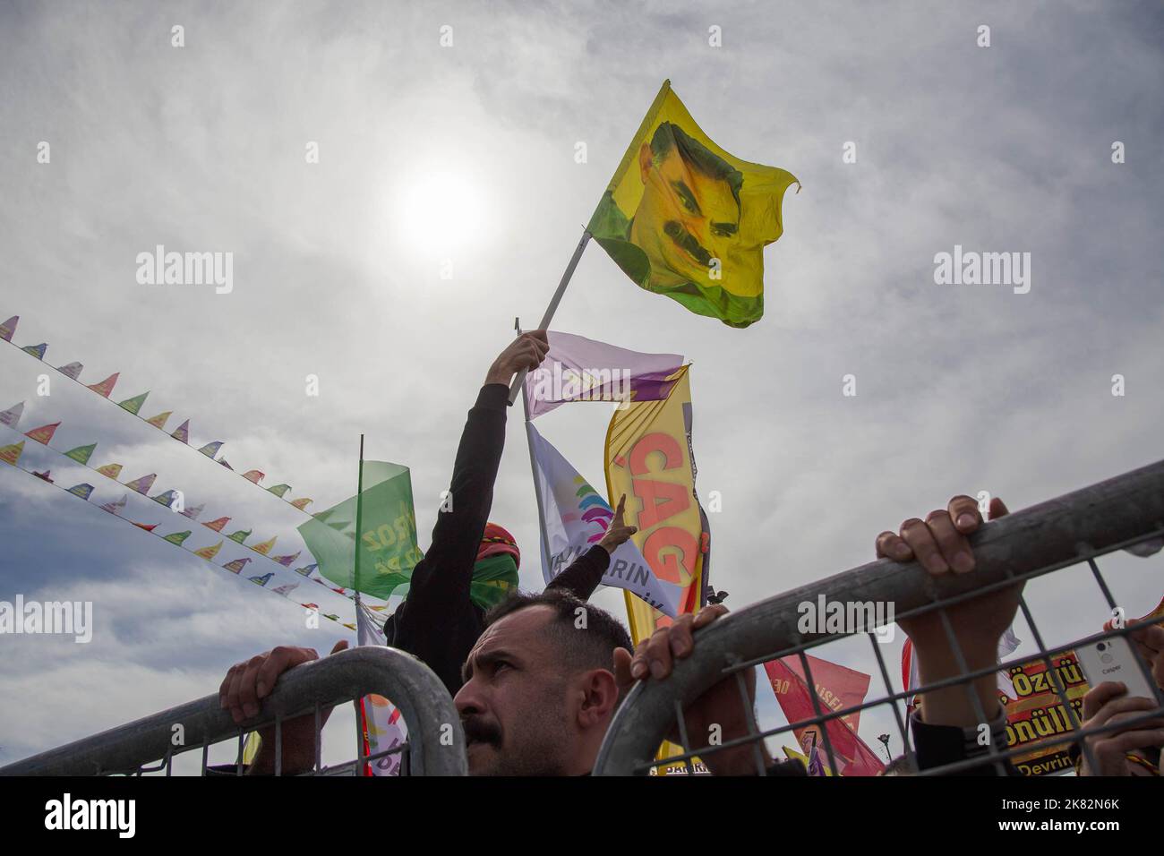 A youth carries a flag with a photo of PKK Leader Abdullah Ocalan ...
