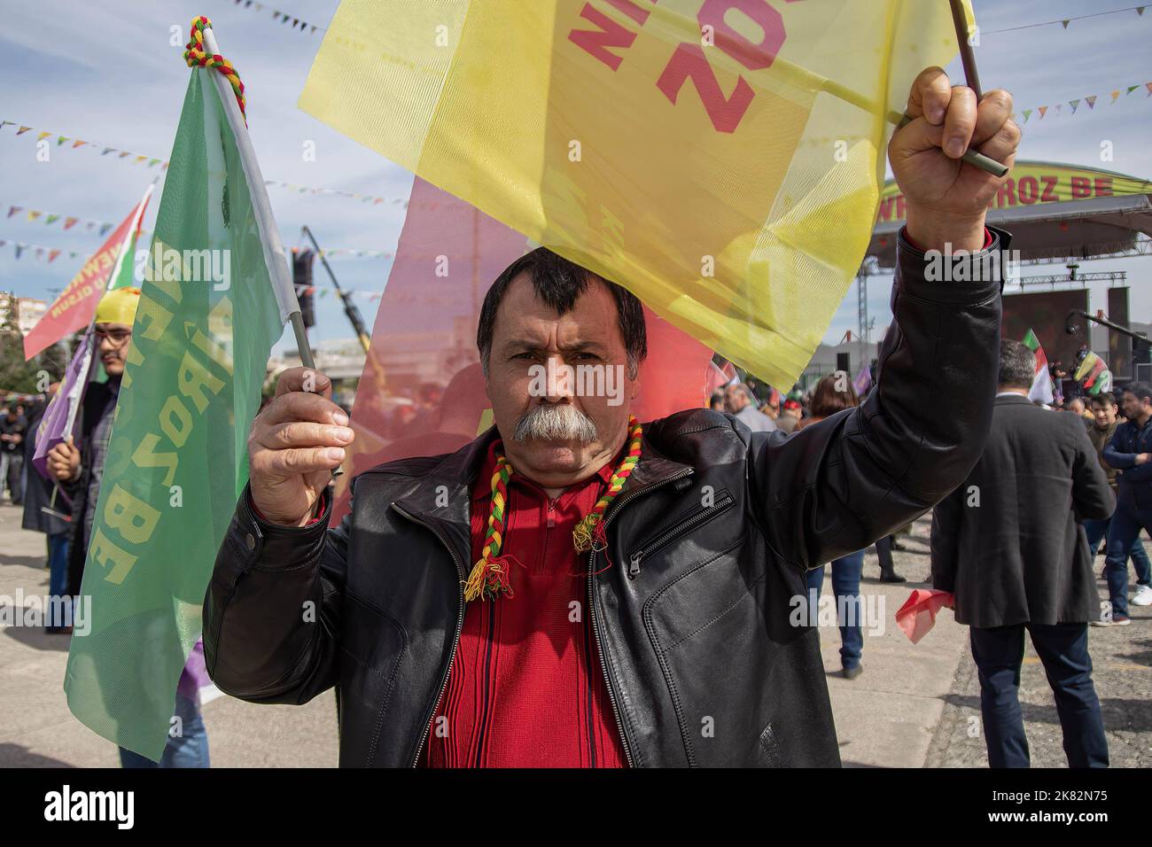 A Kurdish man holds flags during the celebration of the beginning of ...
