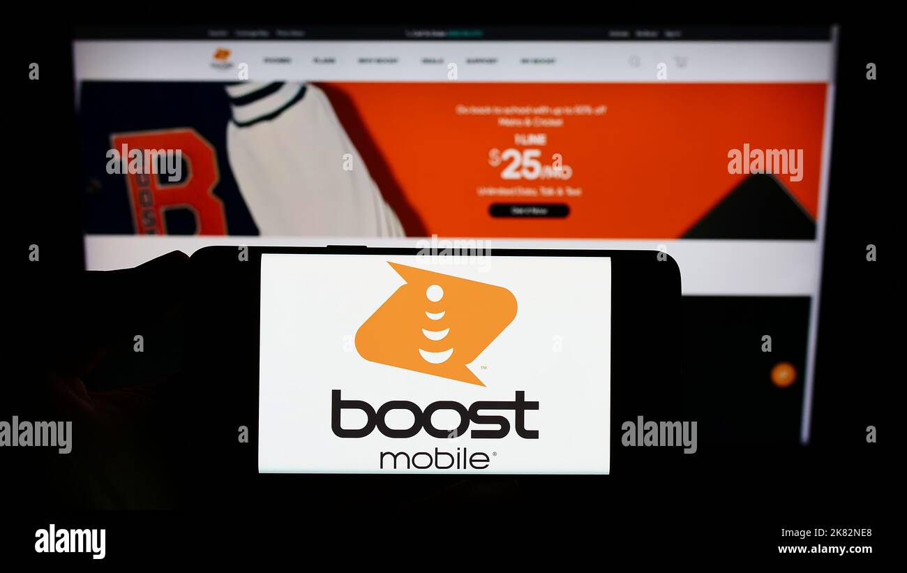 Person holding cellphone with logo of US telecommunications company Boost Mobile on screen in ...