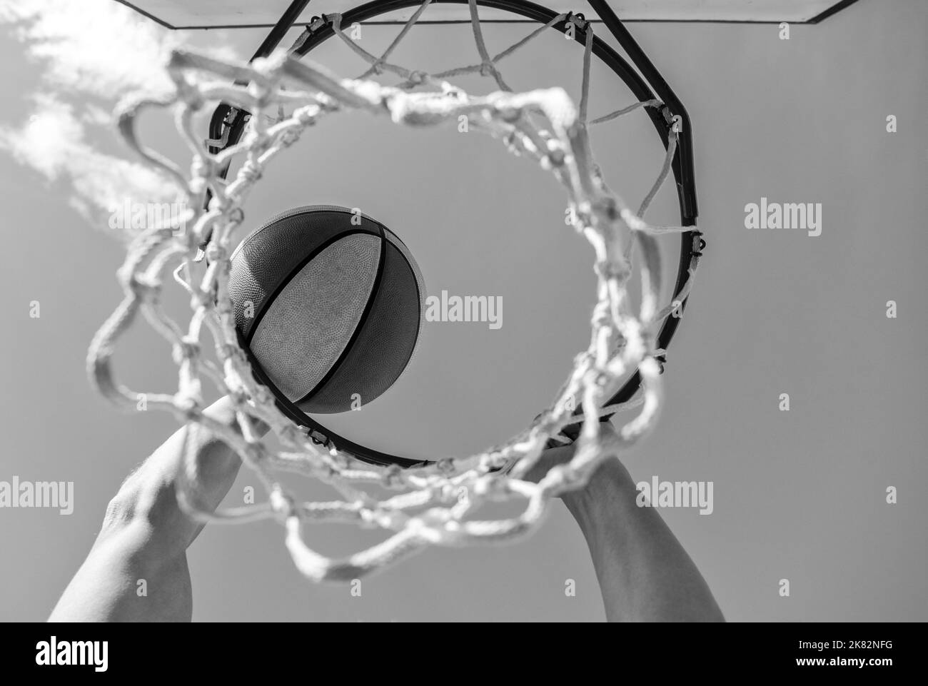 guy dunking basketball ball through net ring with hands, targeting ...