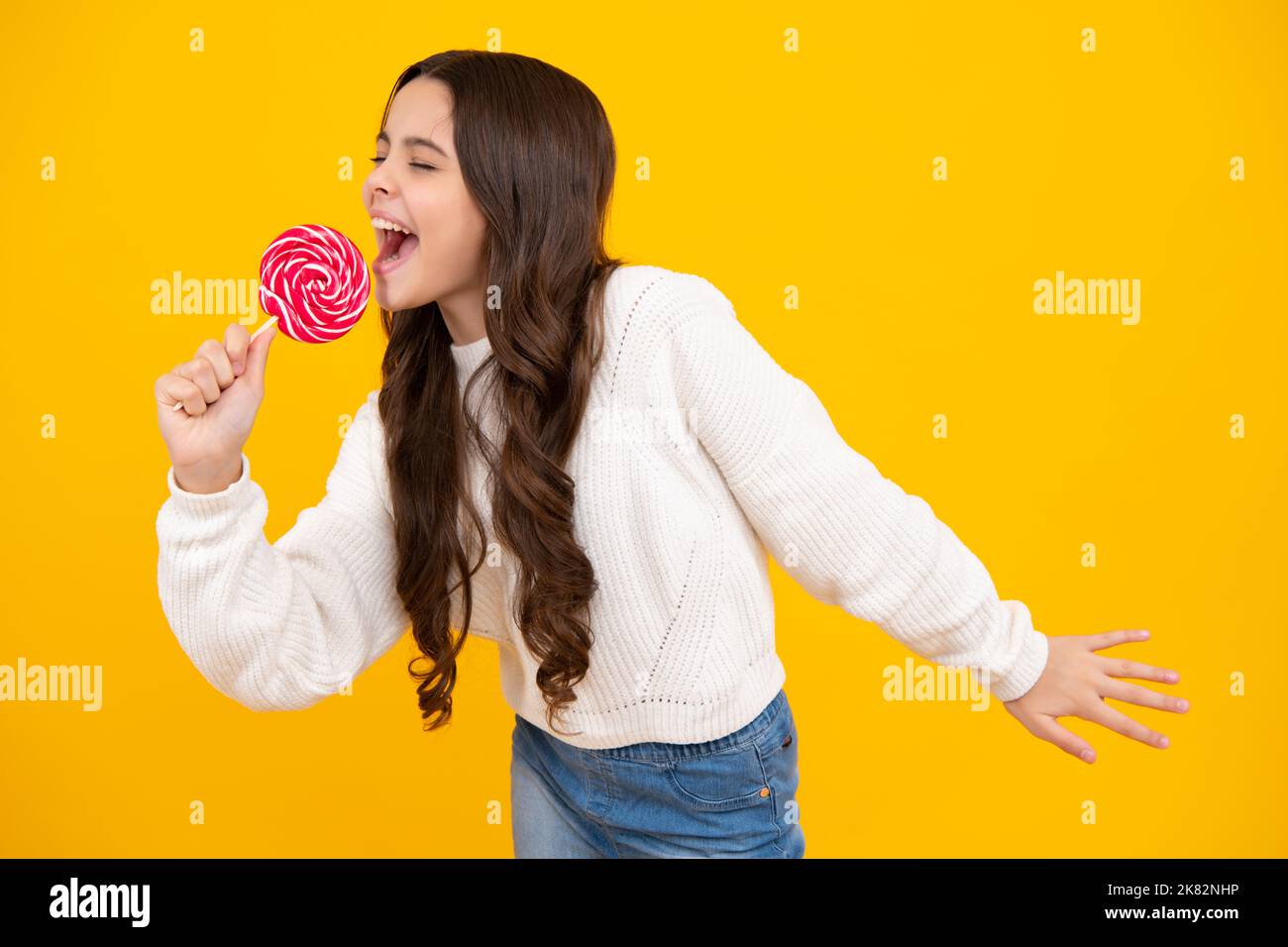 Funny face. Teenager girl with caramel candies on sticks, sweet sugar ...